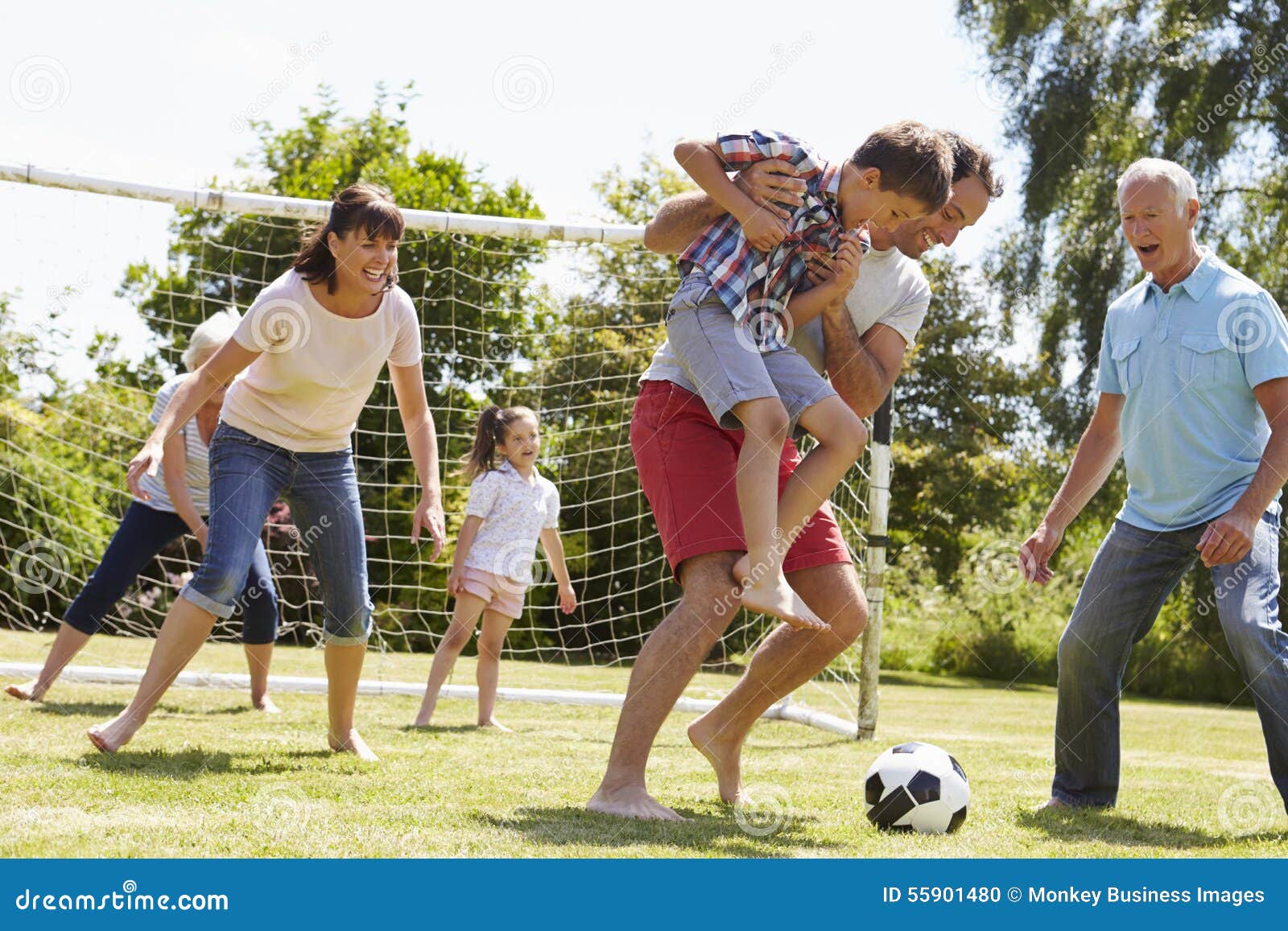 Multi Generation Playing Football in Garden Together Stock Photo ...