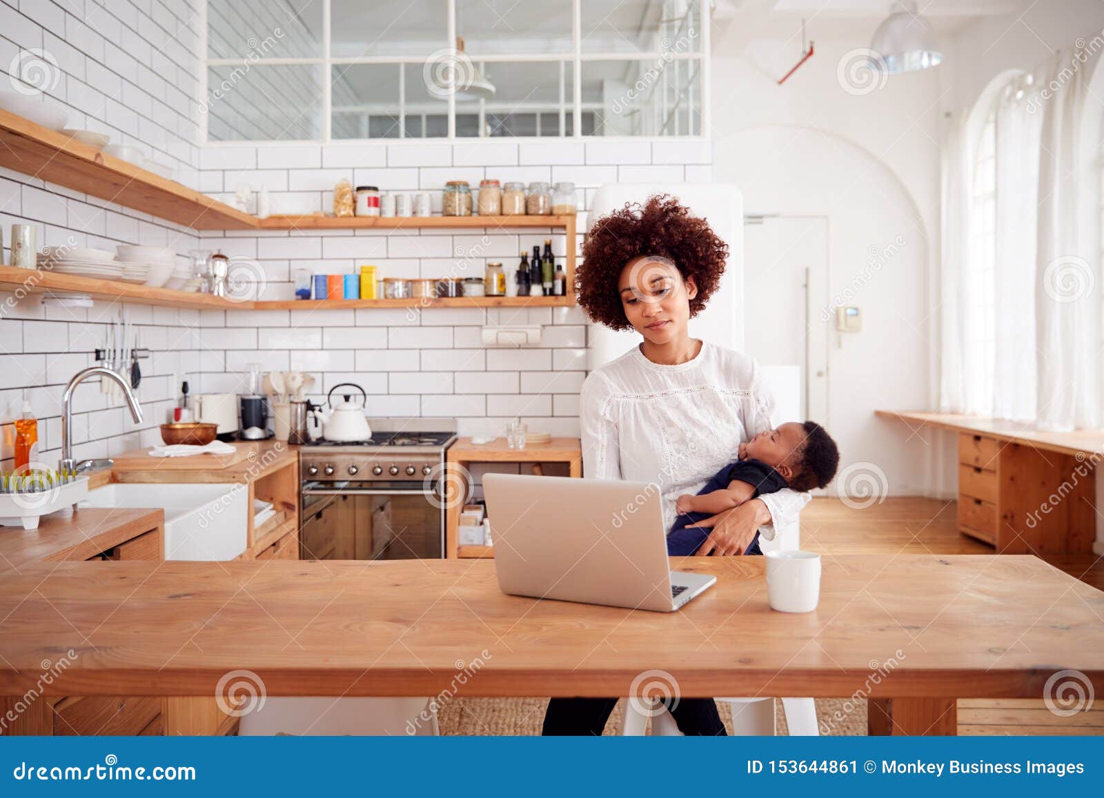 Multi-Tasking Mother Holds Sleeping Baby Son and Works on Laptop ...