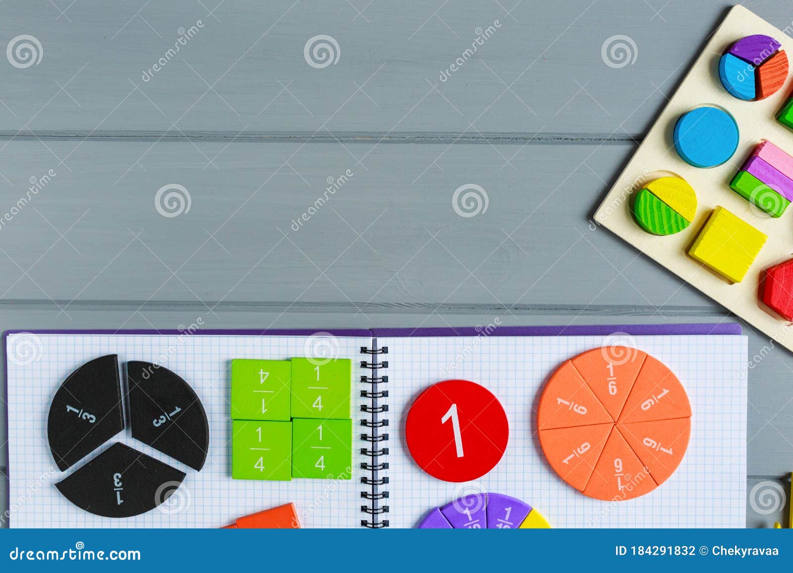 Multicolored Math Fractions on the Open Notepad on Gray Wooden Table ...