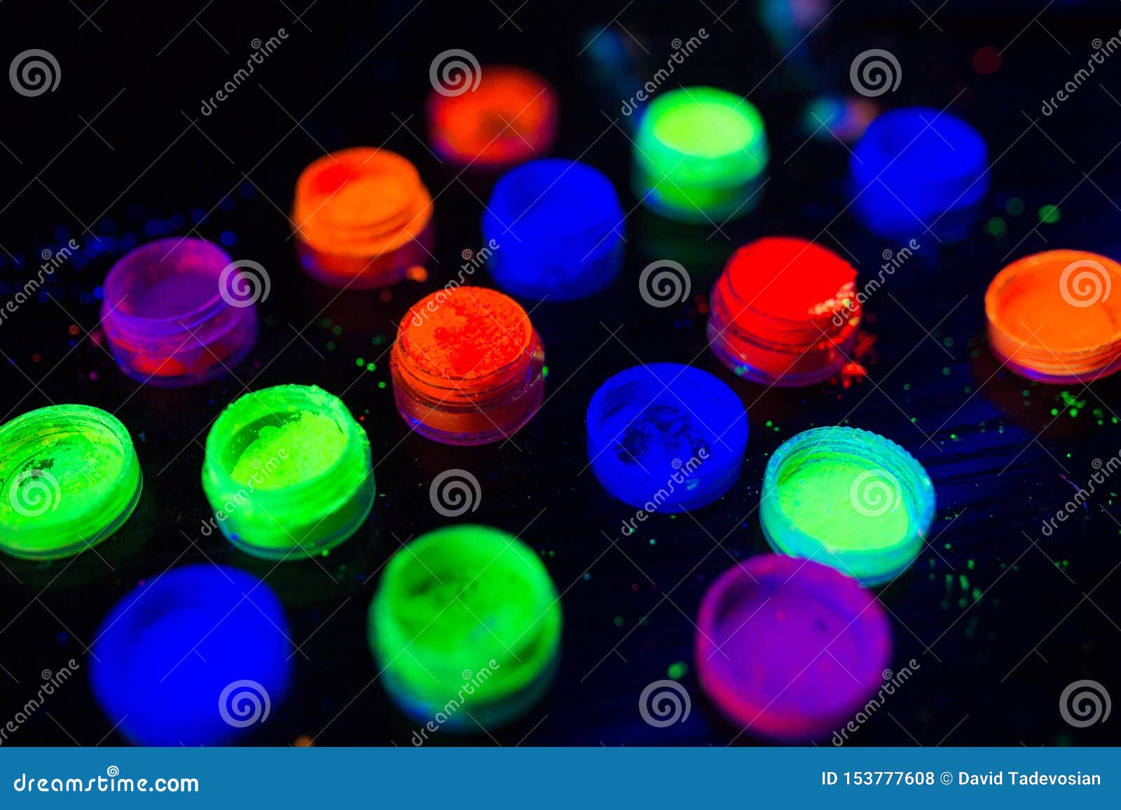 Multicolored UV Powder in Containers on the Black Background. Stock ...