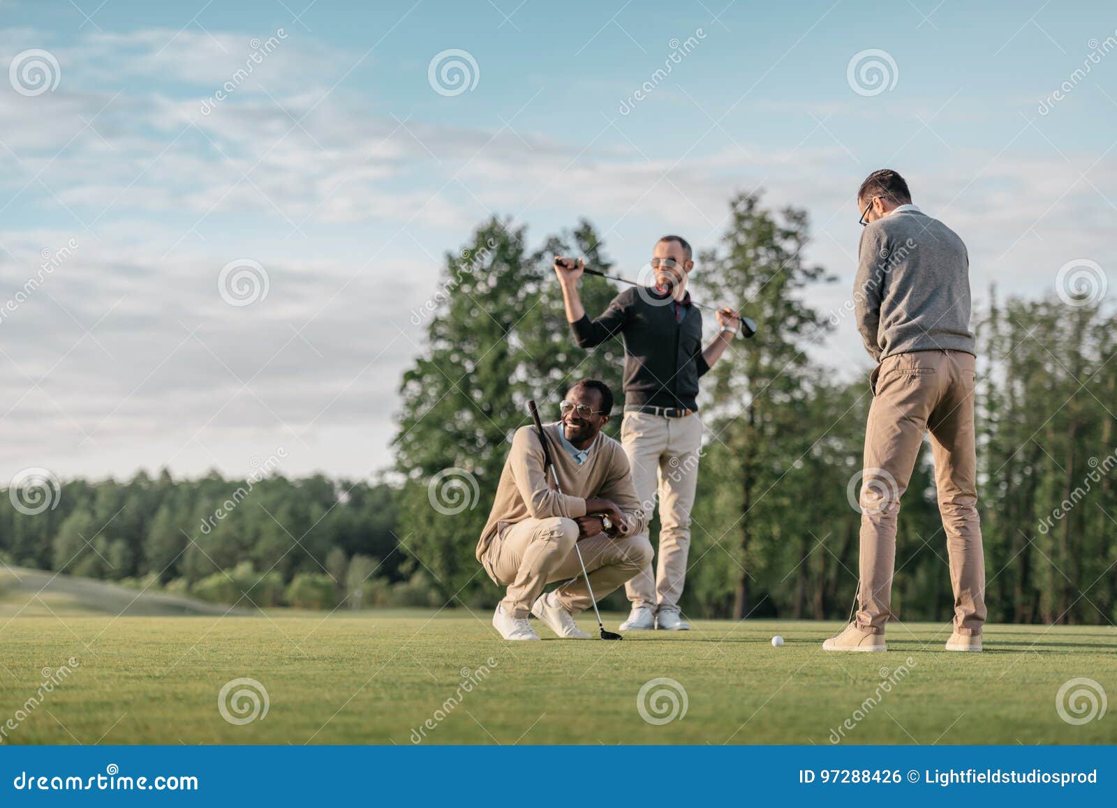 Multicultural Friends Spending Time Together while Playing Golf on Golf ...