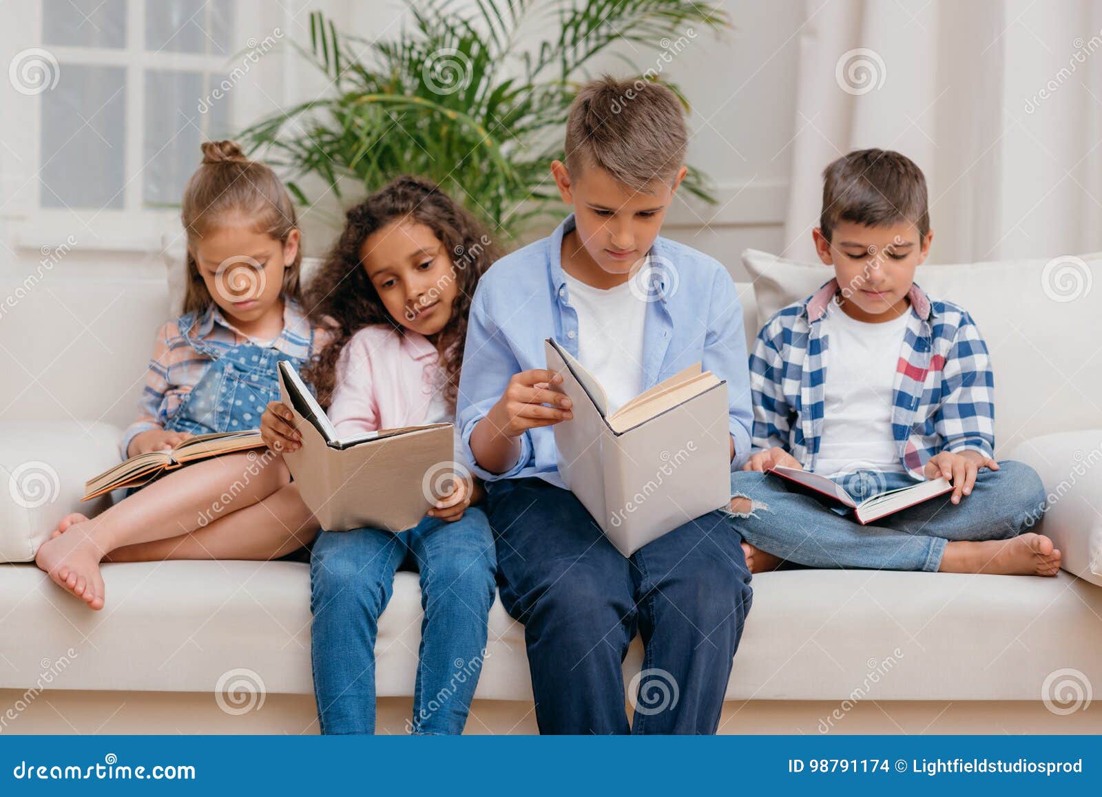 Multicultural Group Of Focused Children Reading Books While Sitting On ...