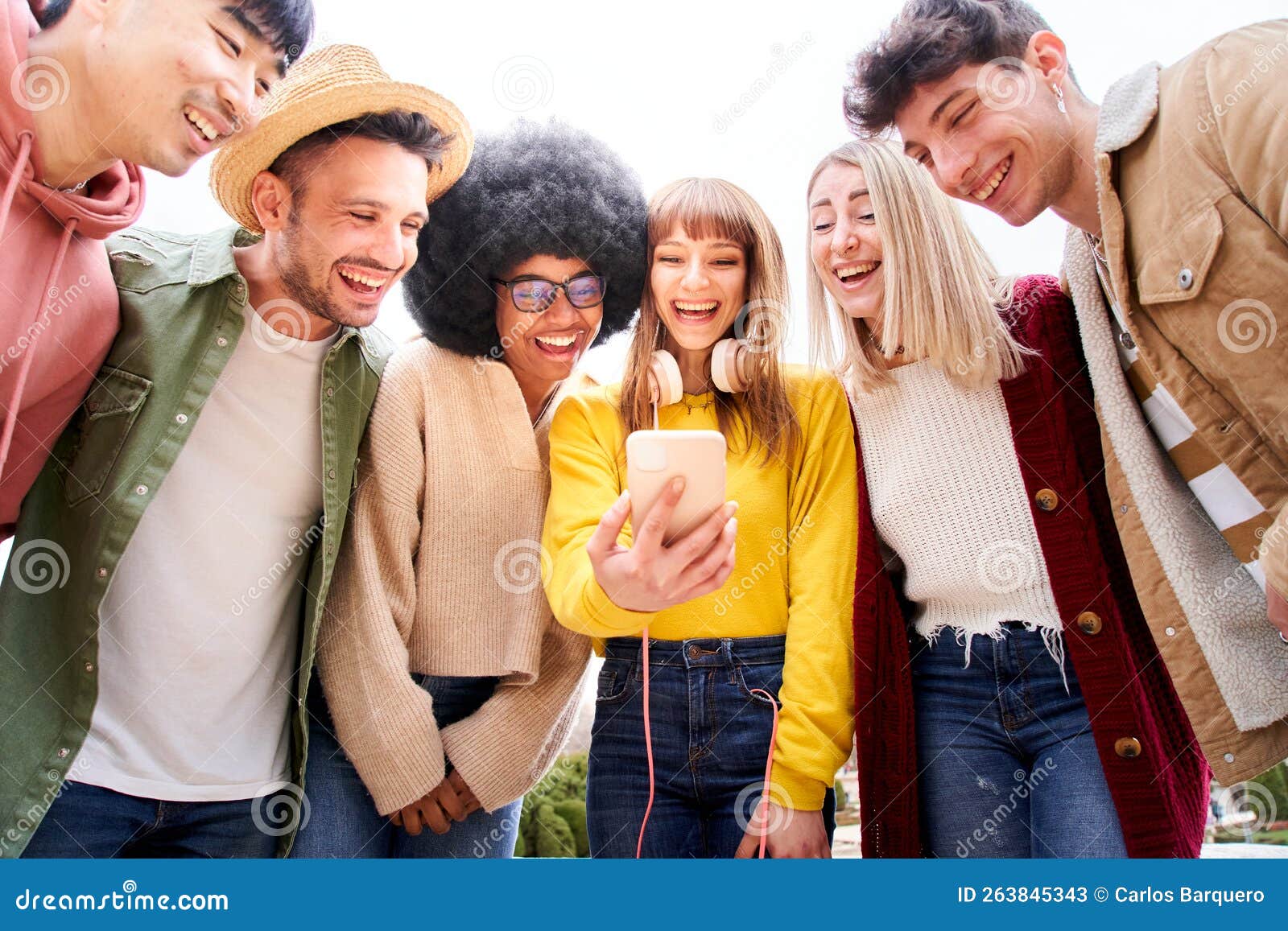 Multicultural Group of Friends Using Cell Phones and Laughing ...