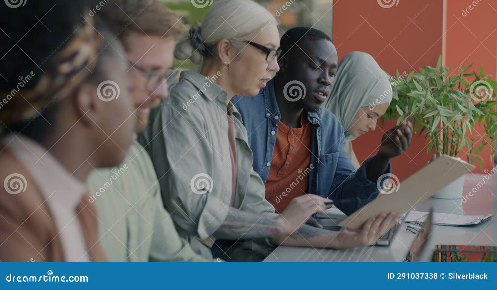 Multicultural Group of Office Workers Talking and Using Computers in ...