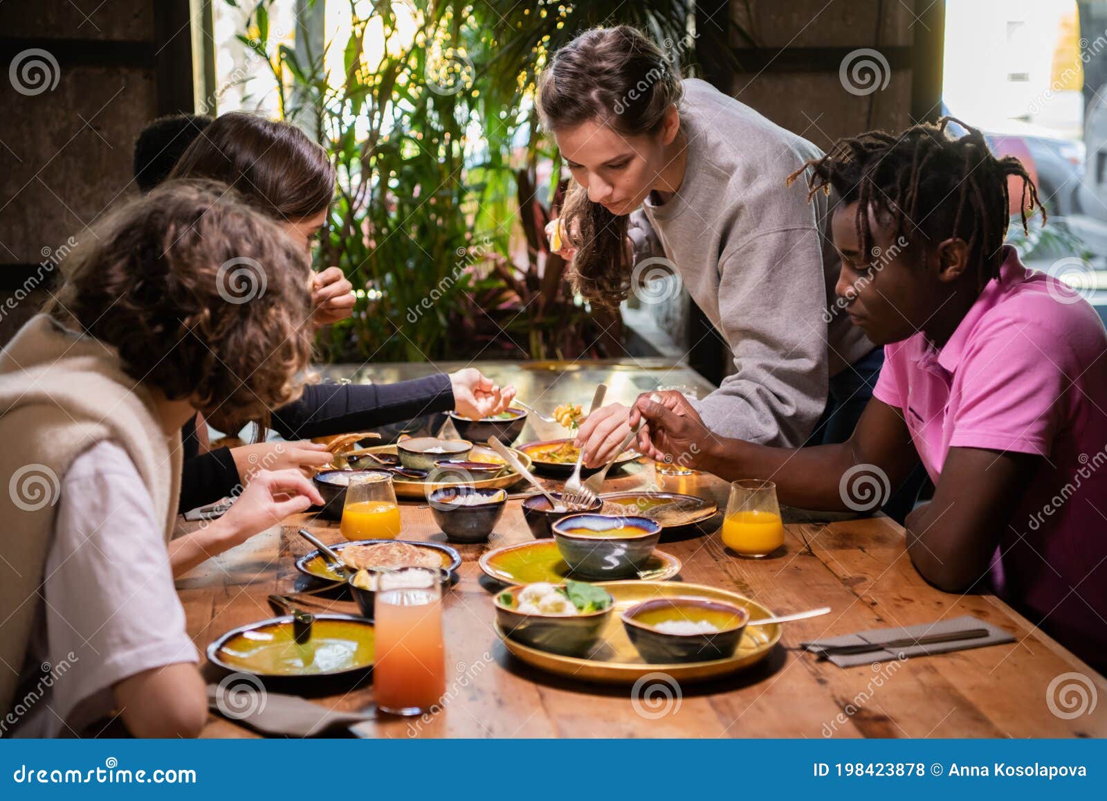 A Multicultural Group of Students Sharing Food in a Cafe Stock Photo ...