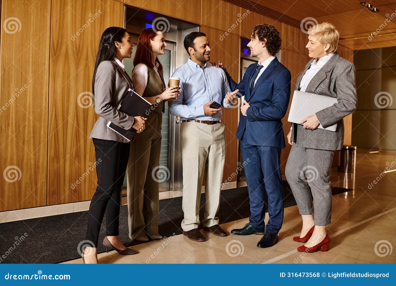 Multicultural Professionals Stand and Converse Animatedly Stock Photo ...