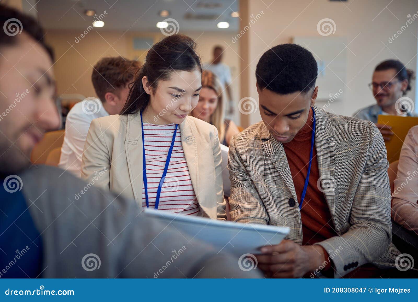 Multietchnic Colleagues Learning Together from a Script at Business ...