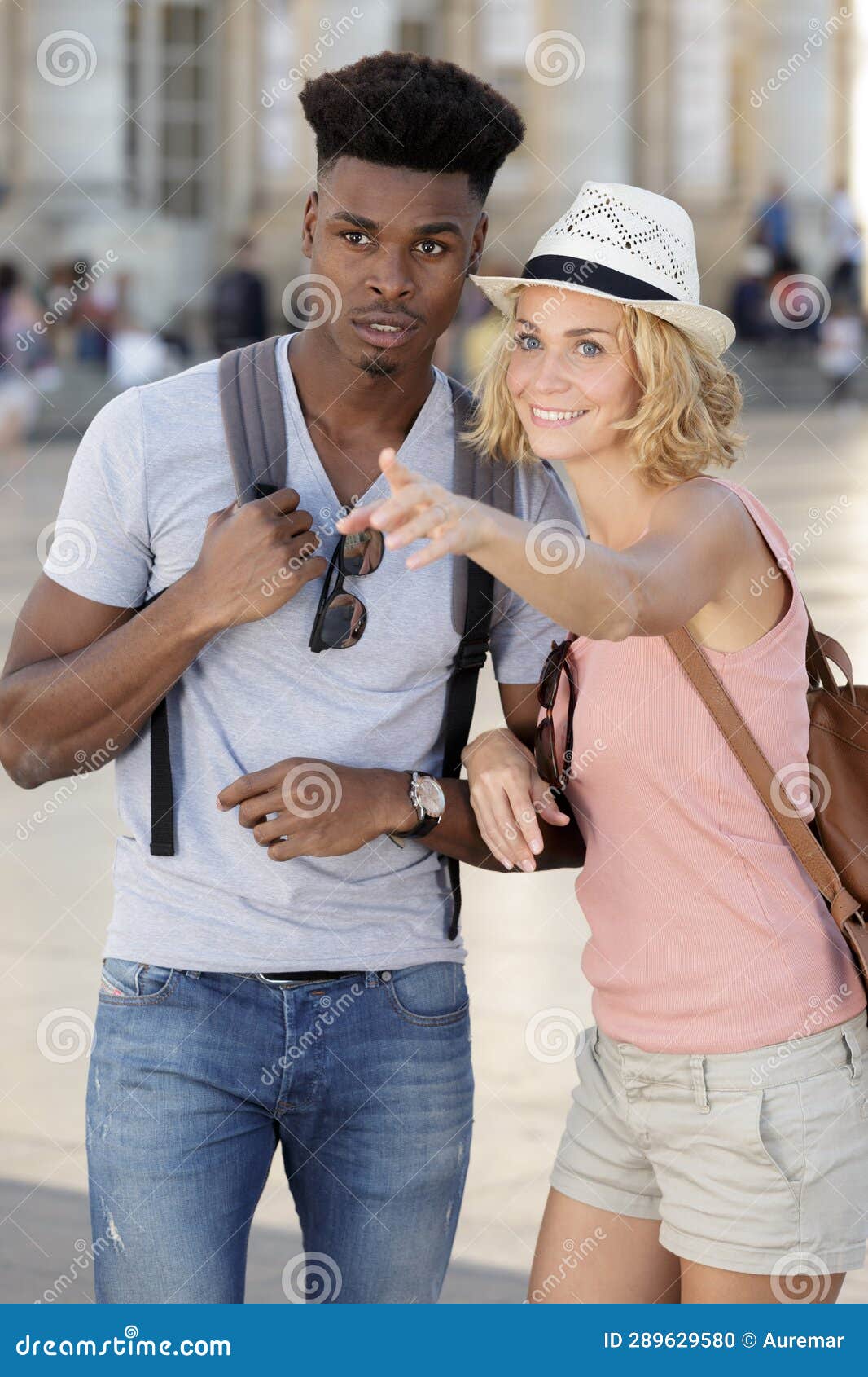 Multiethnic Couple on City Break Pointing into Distance Stock Photo ...