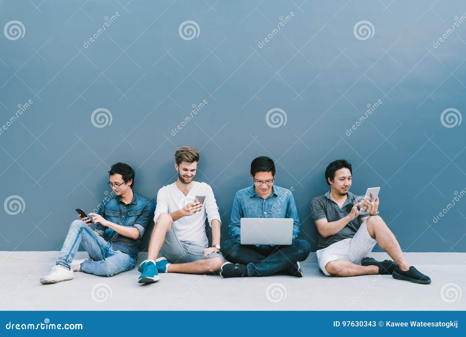Multiethnic Group of Four Men Using Smartphone, Laptop Computer ...