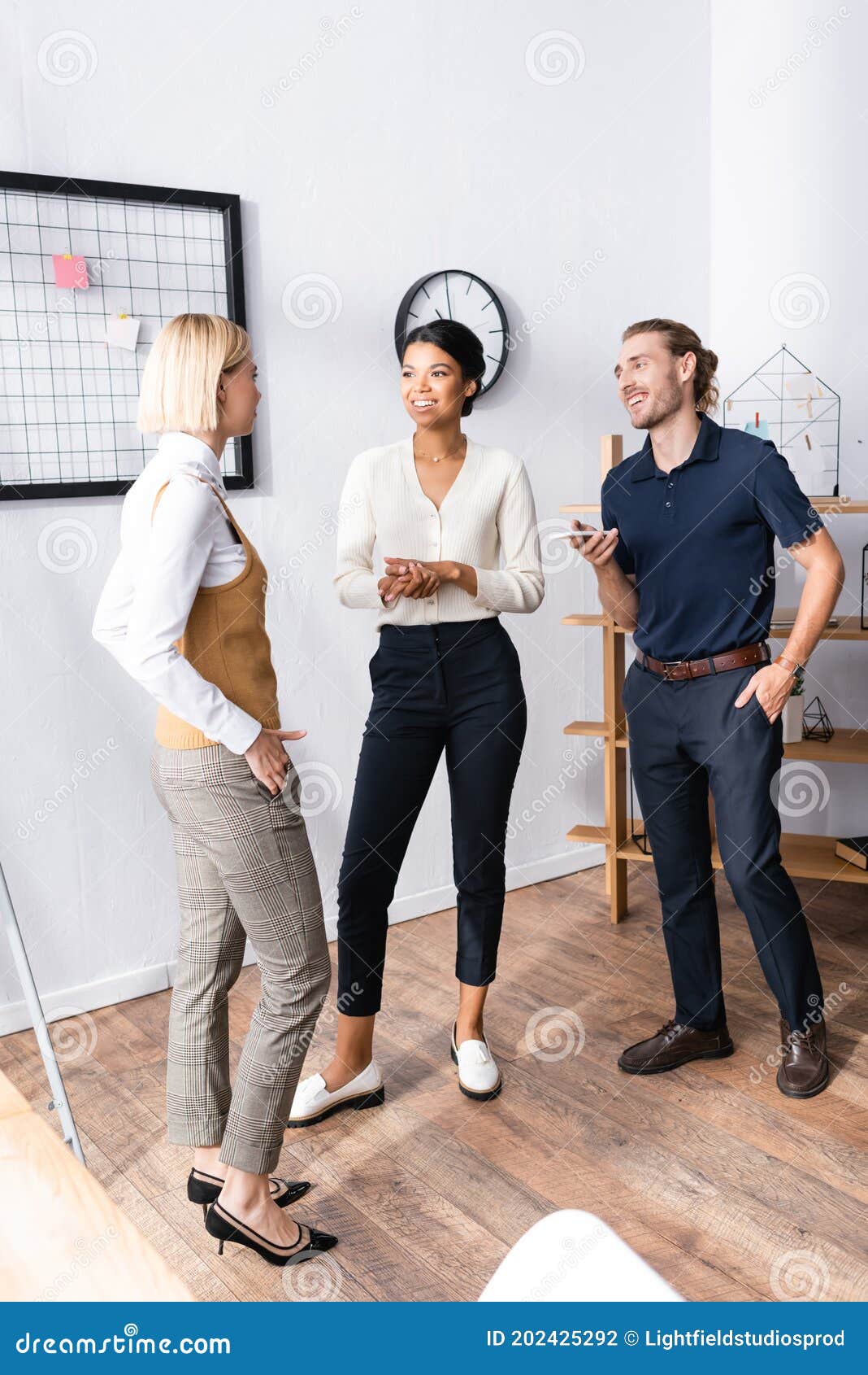 Multiethnic Office Workers Talking while Standing Stock Photo - Image ...