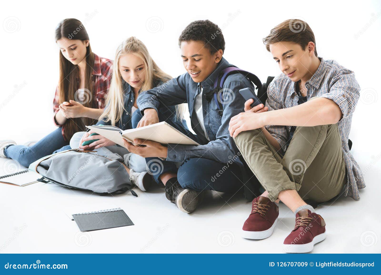 Multiethnic Students Doing Homework while Friends Using Smartphones ...