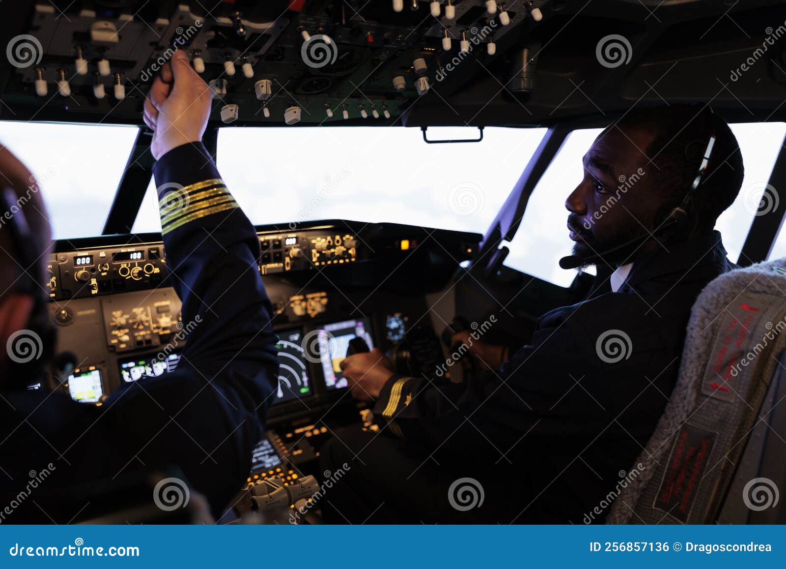 Multiethnic Team of Pilots Using Control Panel in Cockpit To Fly ...
