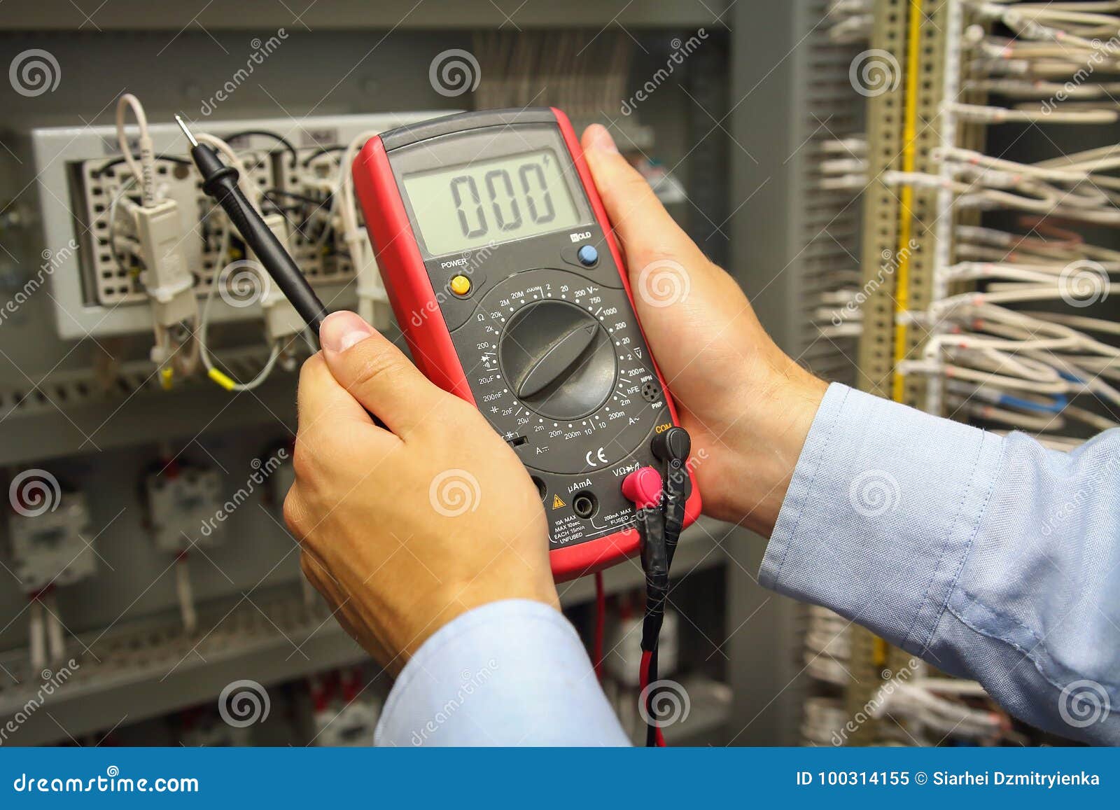 Multimeter in Hands of Electric Engineer on Background of Automation ...