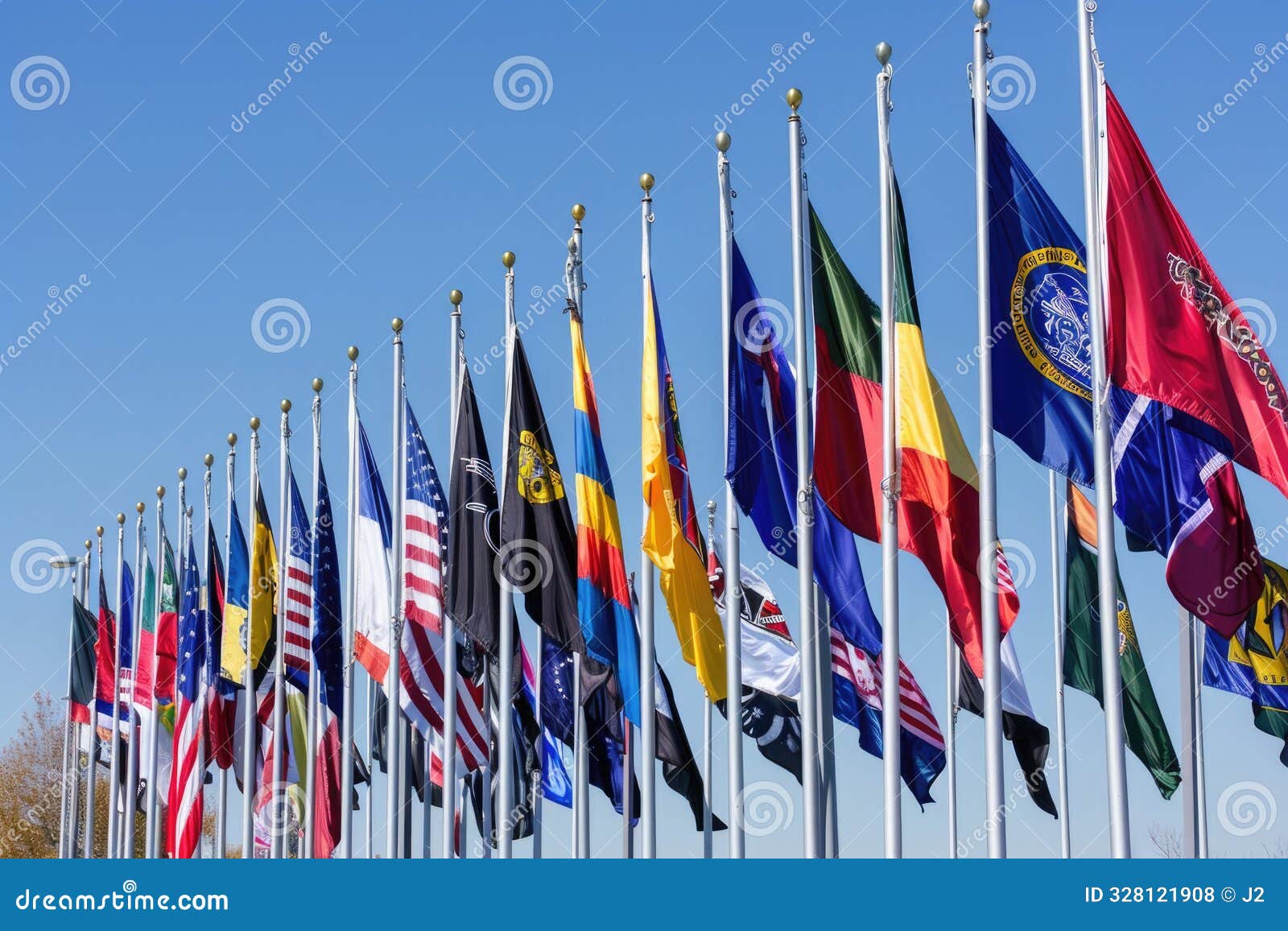 Multiple International Flags Waving on Tall Flagpoles Against a Clear ...
