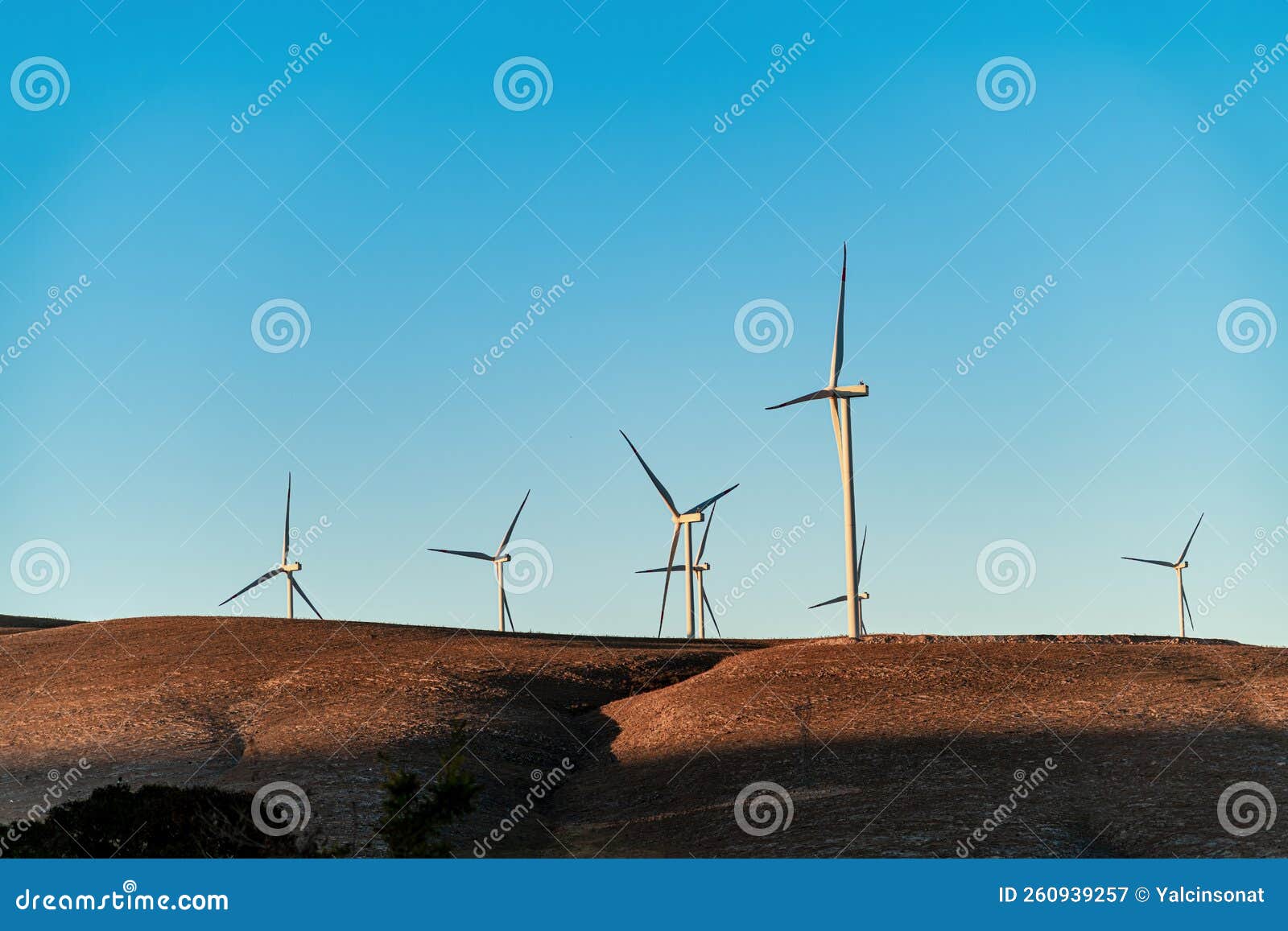 Multiple Wind Turbines Standing on a Hill at Sunrise and Generating ...