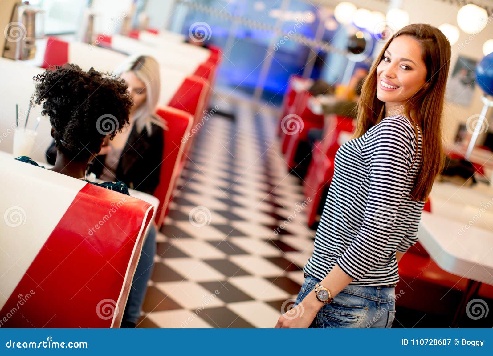 Multiracial Female Friends Eating Fast Food At A Table In The Di Stock