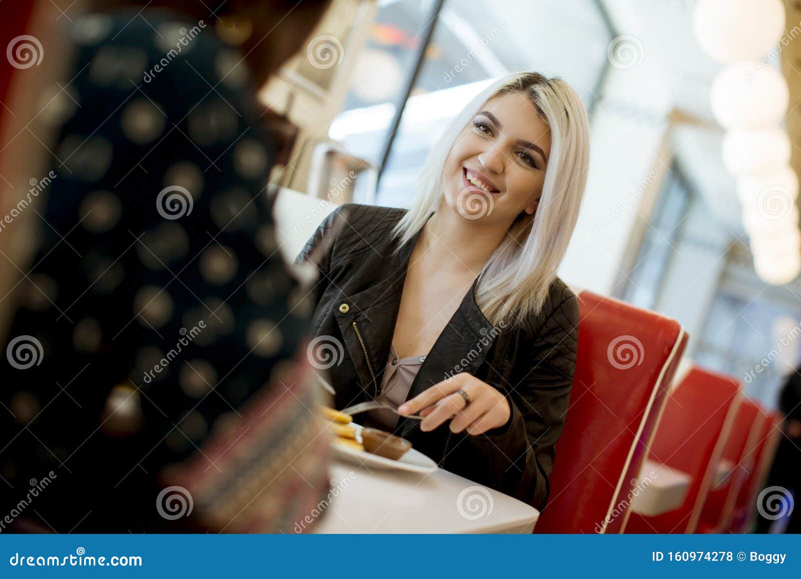 Multiracial Female Friends Eating Fast Food At A Table In The Diner