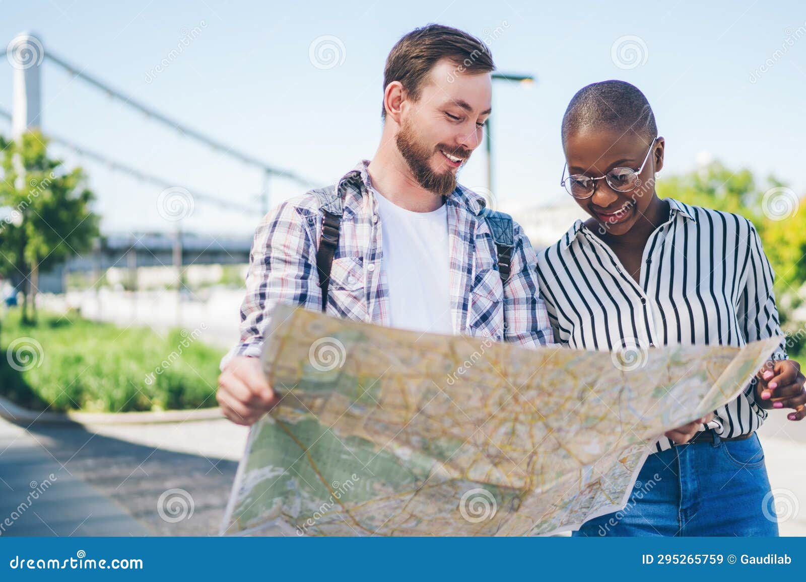 Multiracial Friends Smiling and Watching Open Map on Empty Road Stock ...
