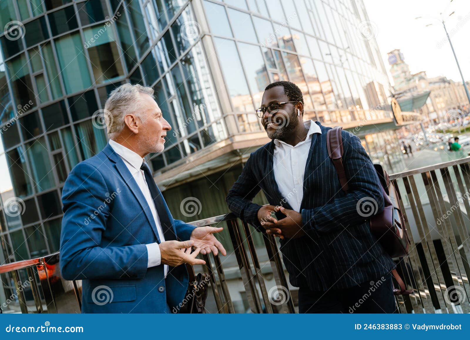 Multiracial Men Talking and Gesturing while Standing by Building Stock ...