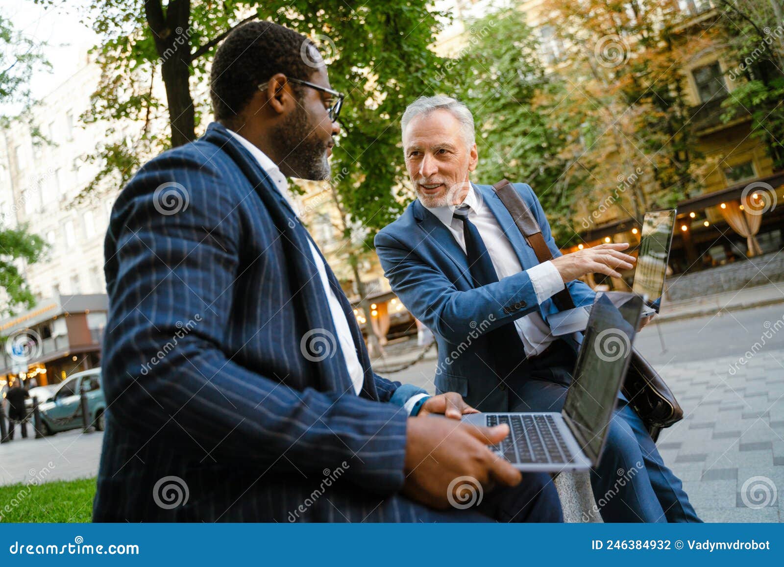 Multiracial Men Talking while Working with Laptops and Drinking Coffee ...