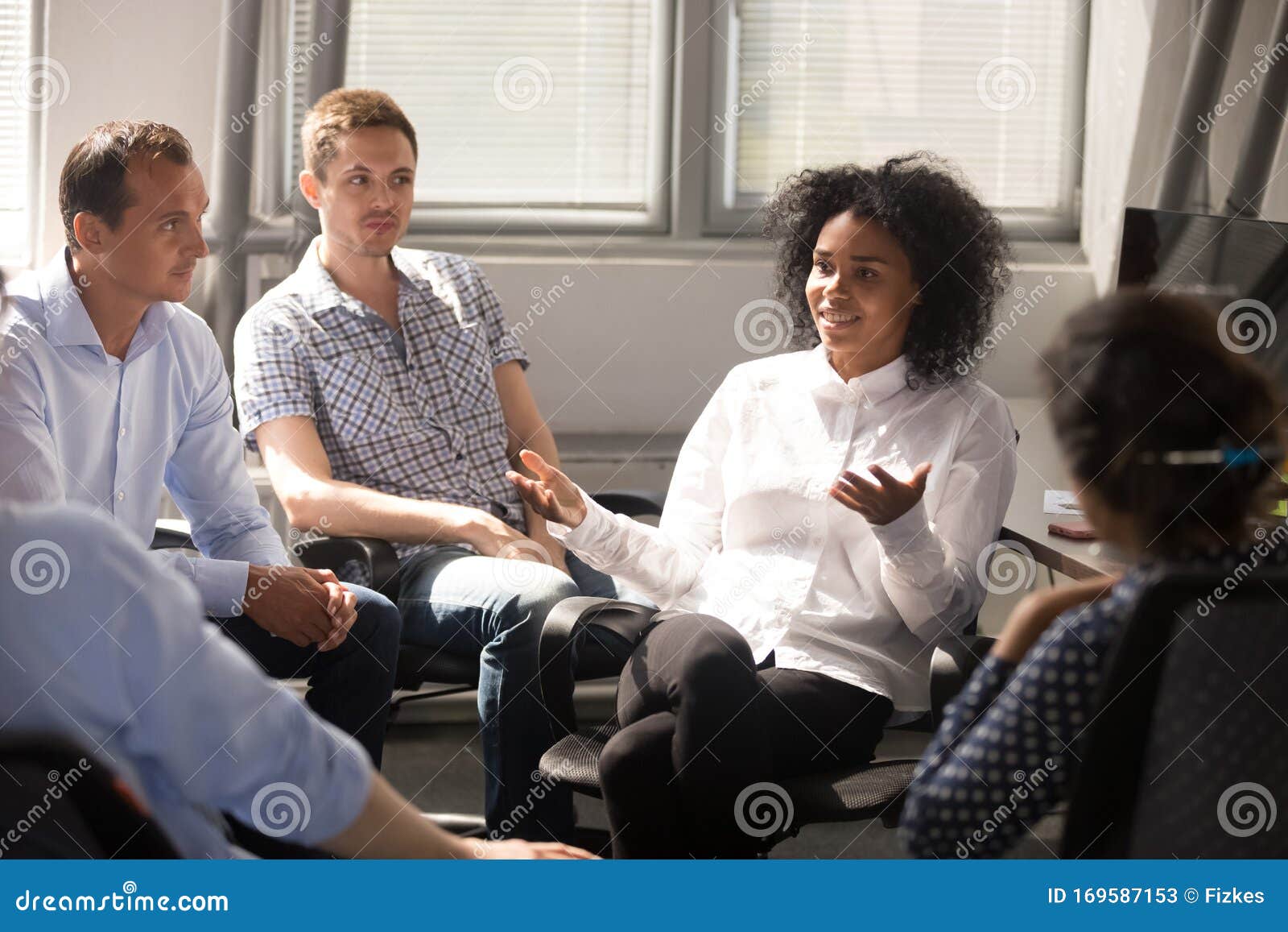 Multiracial Colleagues Talk during Informal Briefing in Office Stock ...