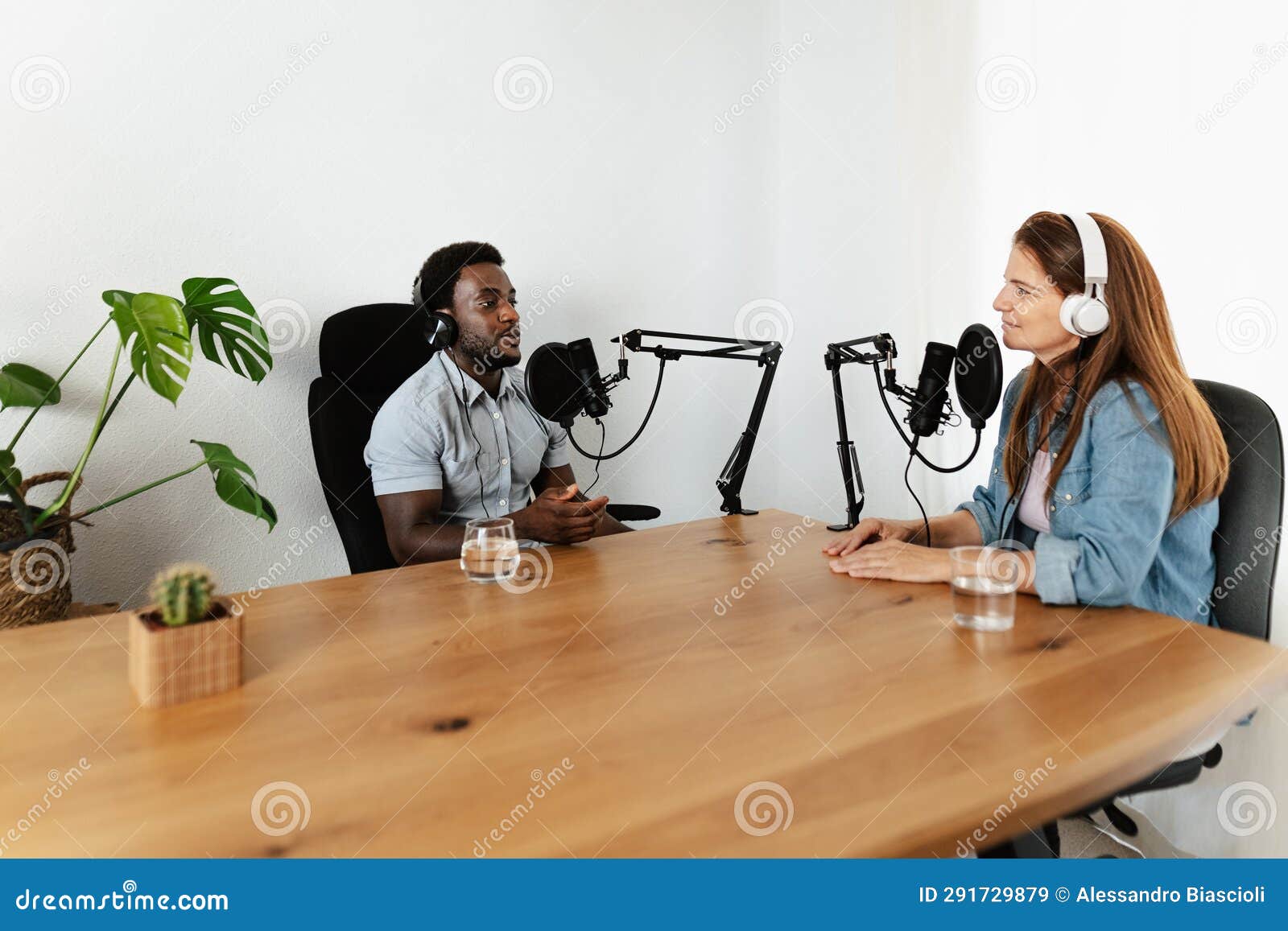 Multiracial People Recording a Podcast Using Microphone and Headphones ...