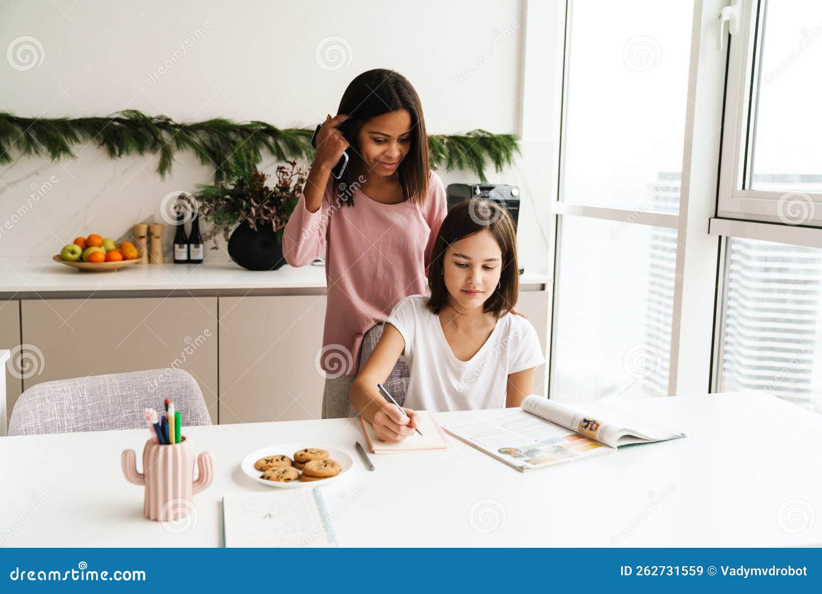 Multiracial Sisters Smiling while Doing Homework Together Stock Image ...