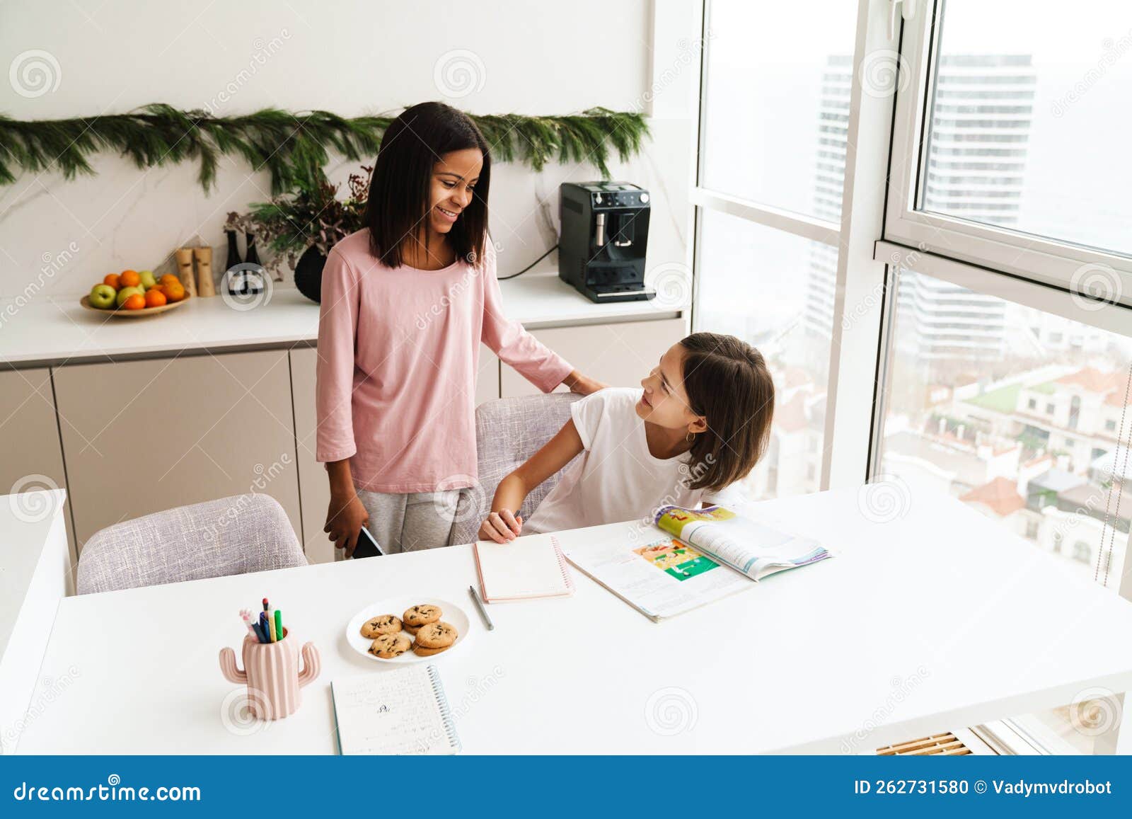 Multiracial Sisters Smiling while Doing Homework Together Stock Photo ...