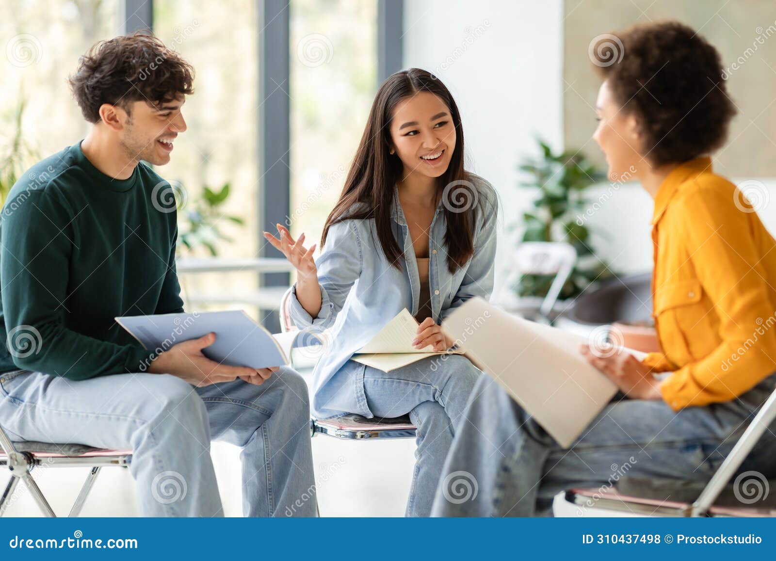 Multiracial Students Discussing Notes in Lively Group Study Session ...