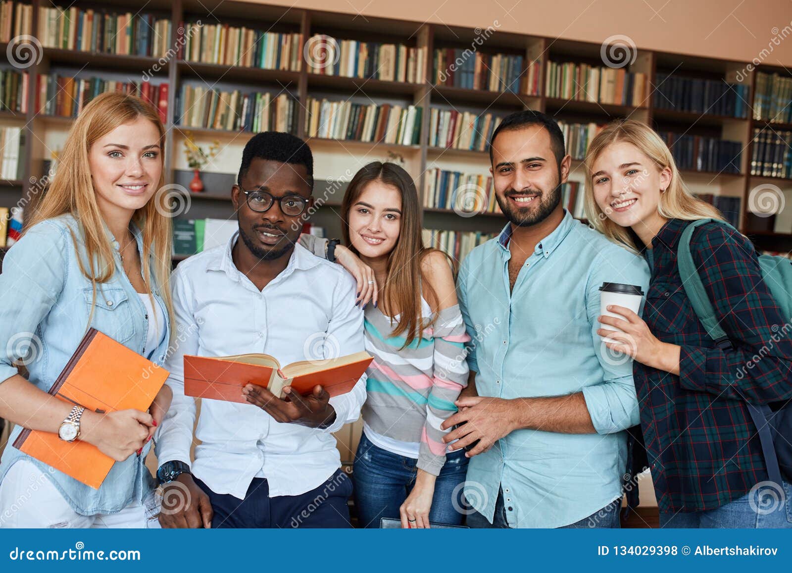Multiracial Students Having Fun in Library while Preparing for Exams ...