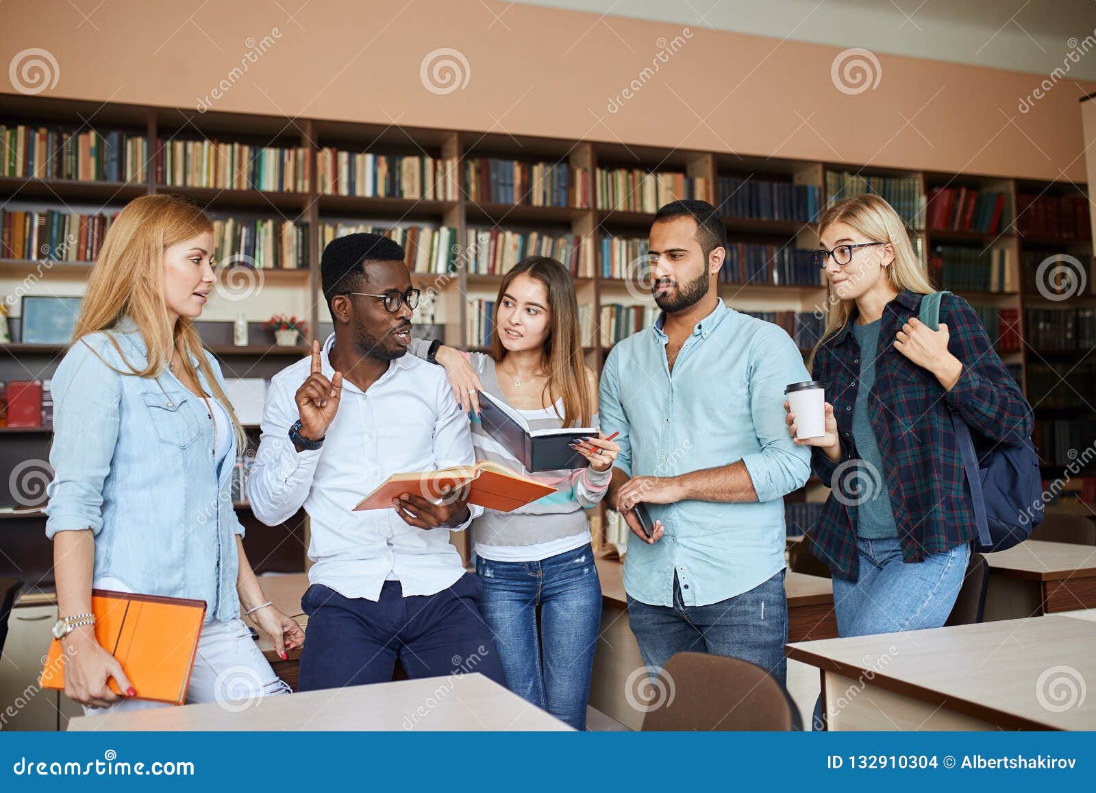 Multiracial Students Having Fun in Library while Preparing for Exams ...