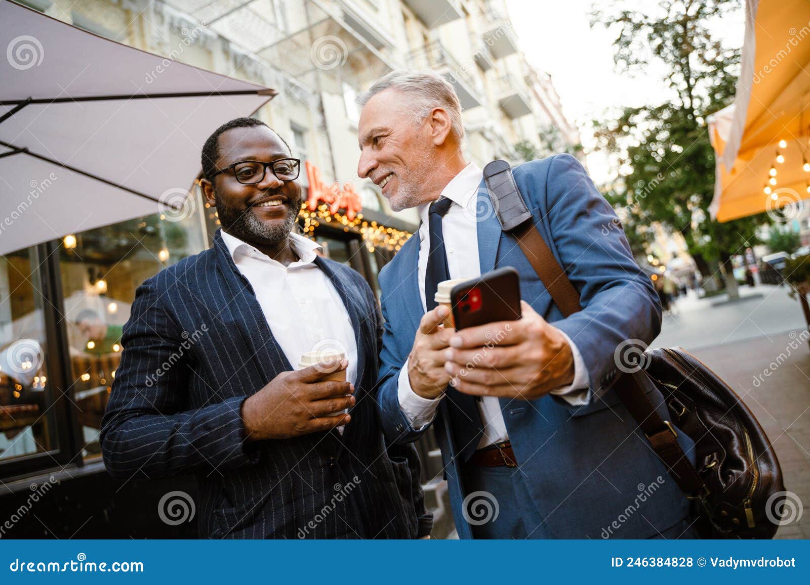 Multiracial Two Men Using Cellphone and Talking while Drinking Coffee ...