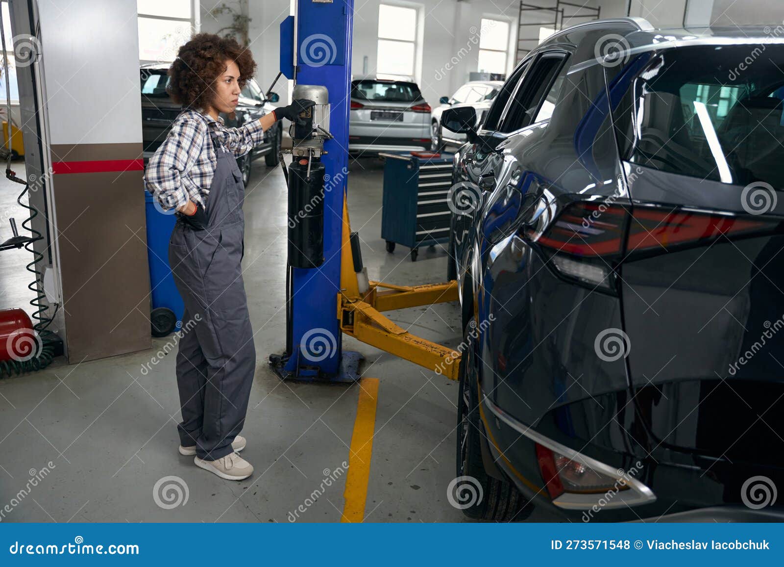 Multiracial Woman Fixes the Car on a Special Lift Stock Photo - Image ...