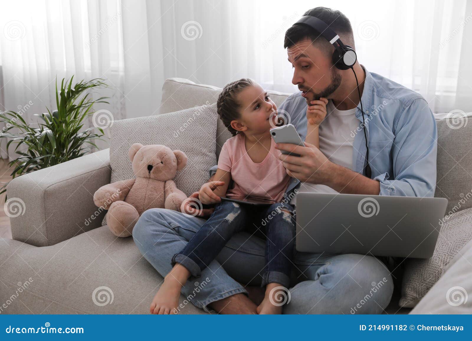 Multitasking Man Combining Parenting and Work at Home Stock Photo ...