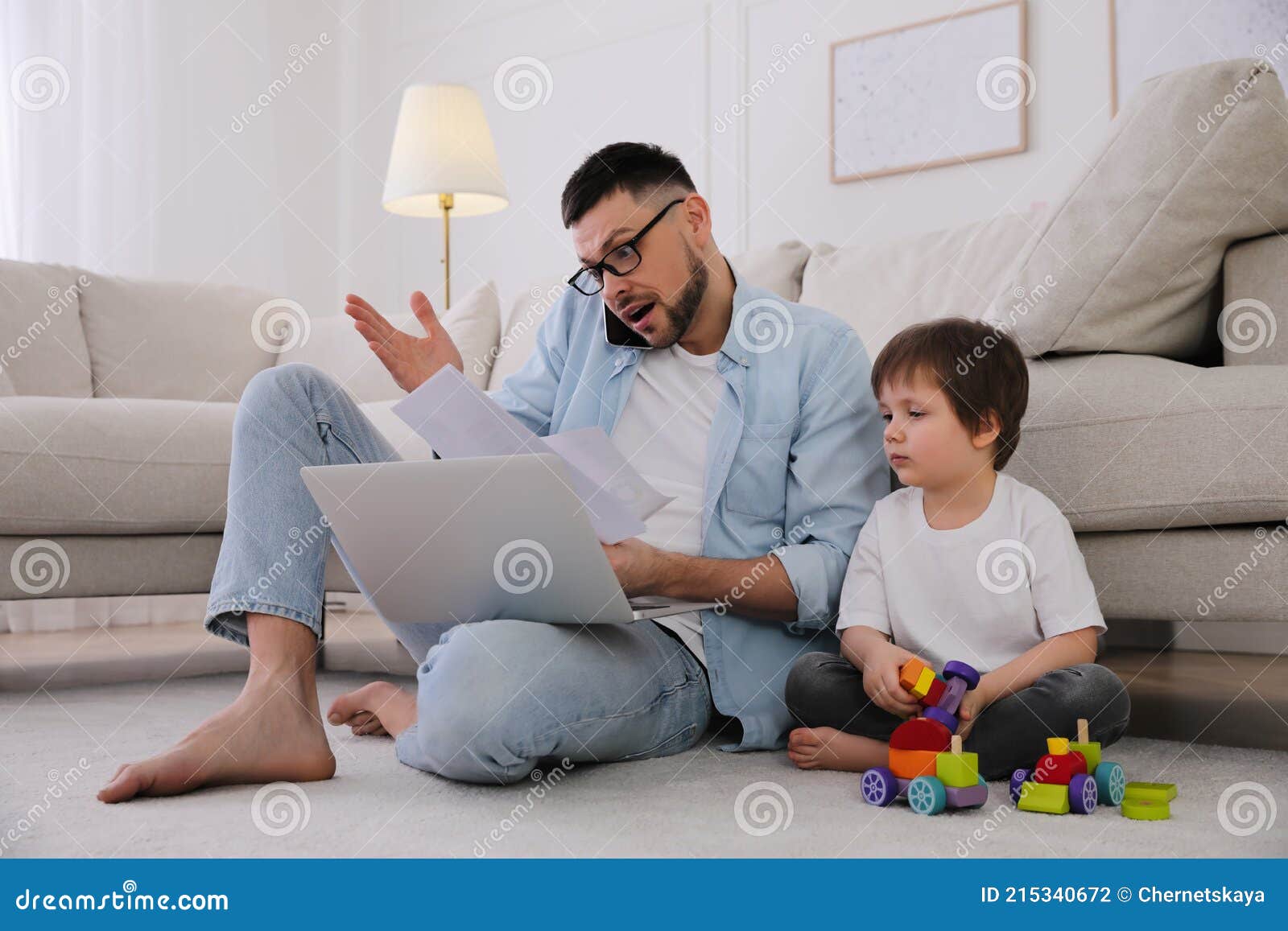 Multitasking Man Combining Parenting and Work at Home Stock Photo ...