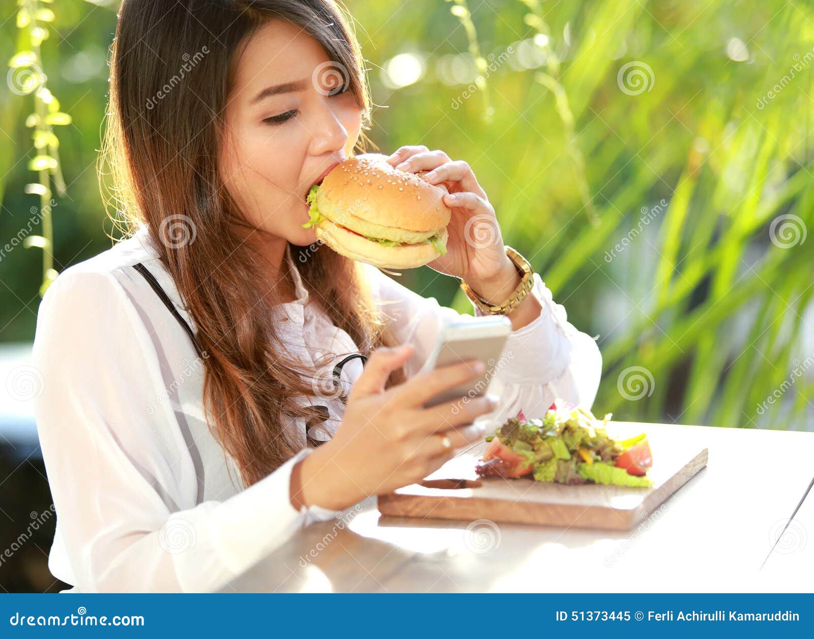 Multitasking Woman Having Lunch while Texting on Her Mobilephone Stock ...