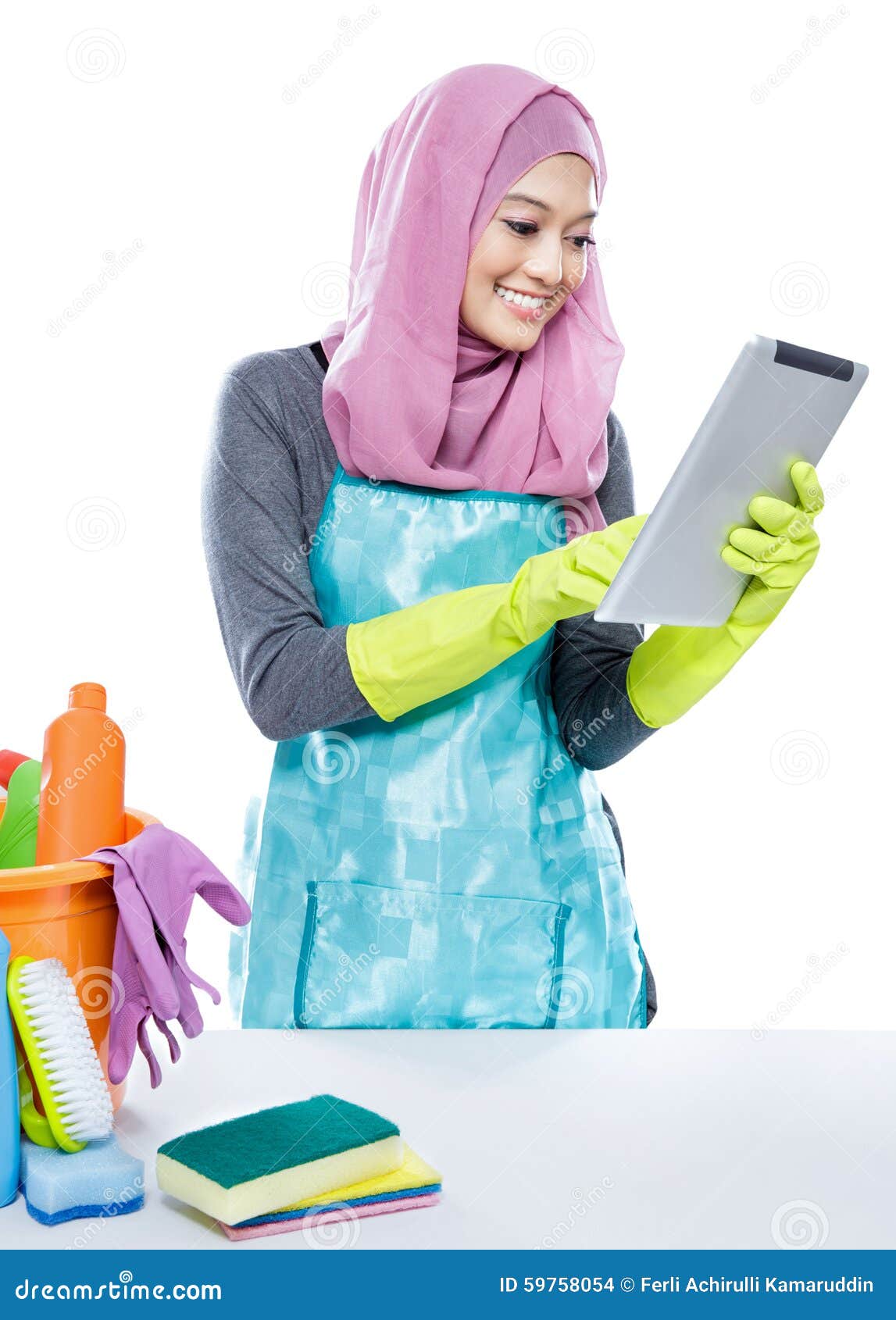 Multitasking Young Housewife Using Tablet while Cleaning a Table Stock ...