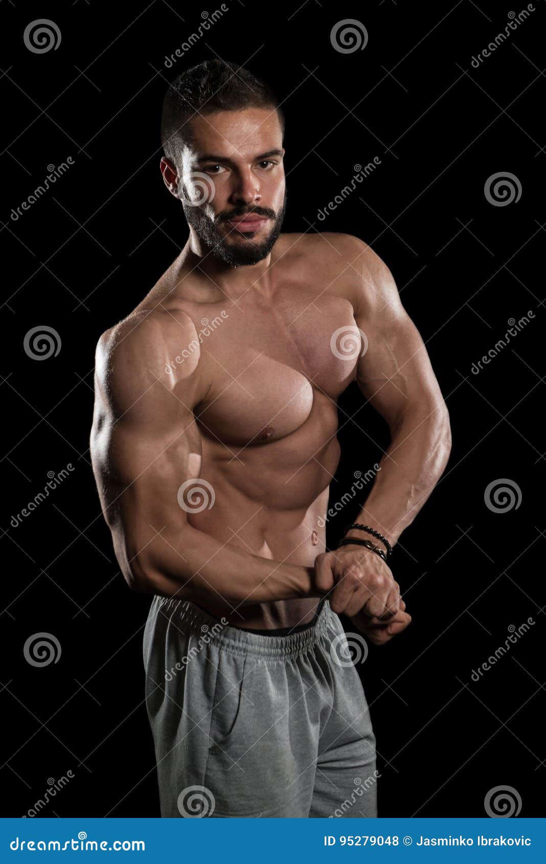 Muscular Athlete Flexing Muscles on Black Background Stock Photo ...