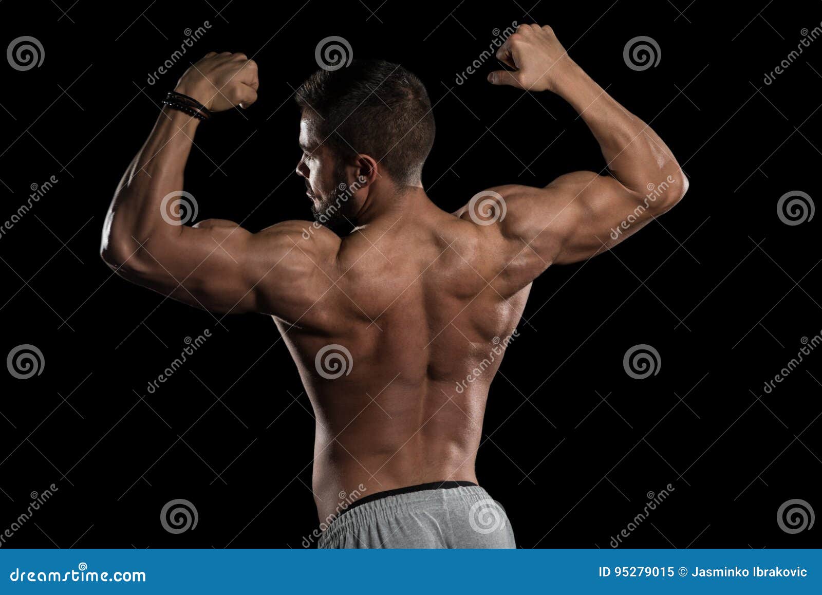 Muscular Athlete Flexing Muscles on Black Background Stock Image ...