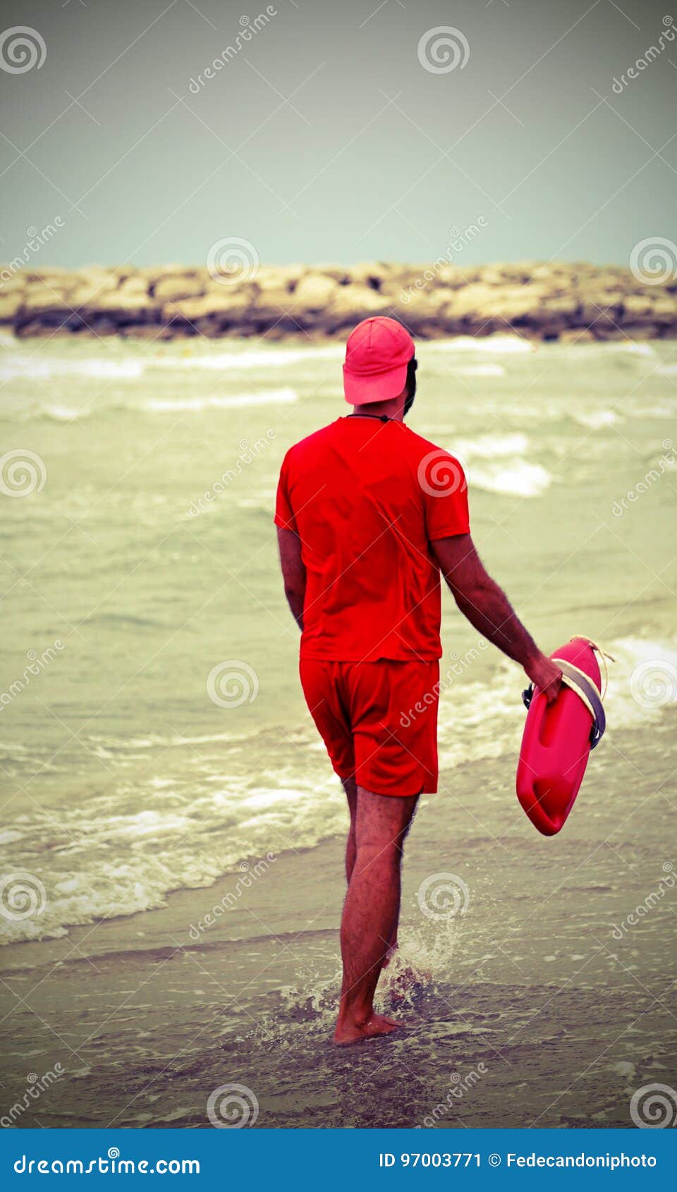 Muscular Barefoot Lifeguard with Red Uniform Controls the Coast ...