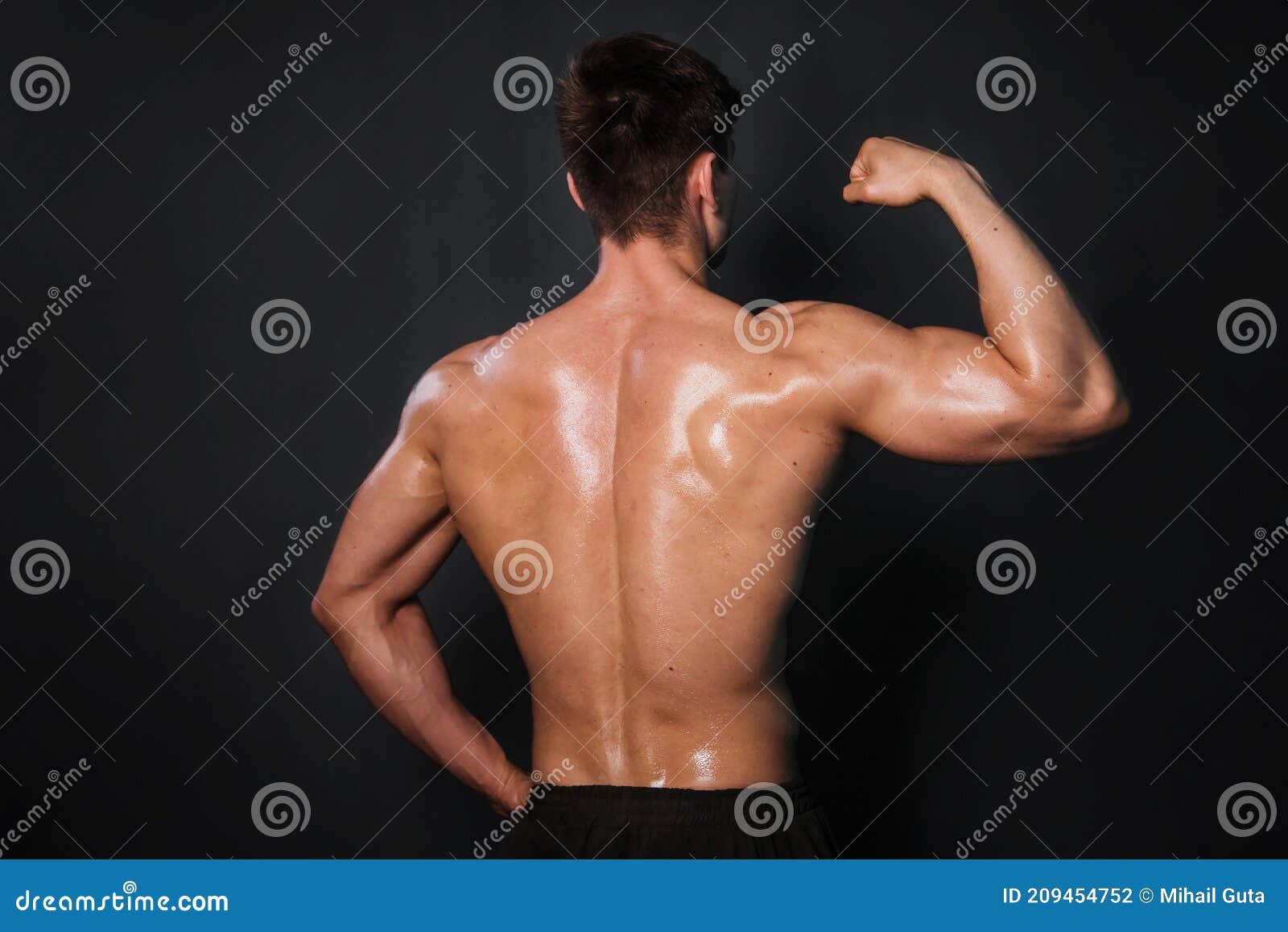 Muscular Bodybuilder Man Posing on Black Background. View from the Back ...