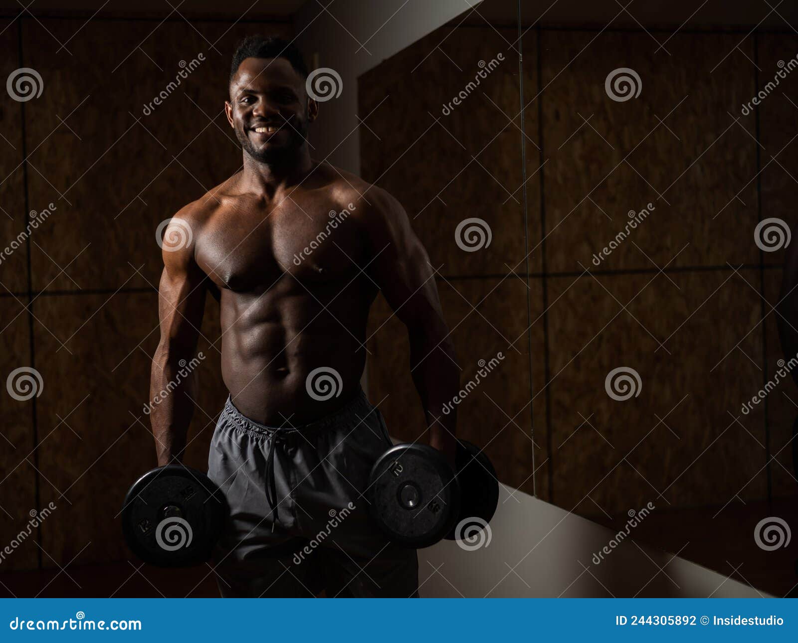 Muscular Dark-skinned Man Doing an Exercise with Dumbbells. Stock Photo ...