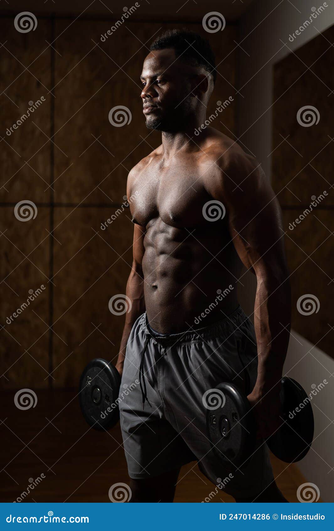 Muscular Dark-skinned Man Doing an Exercise with Dumbbells. Stock Photo ...