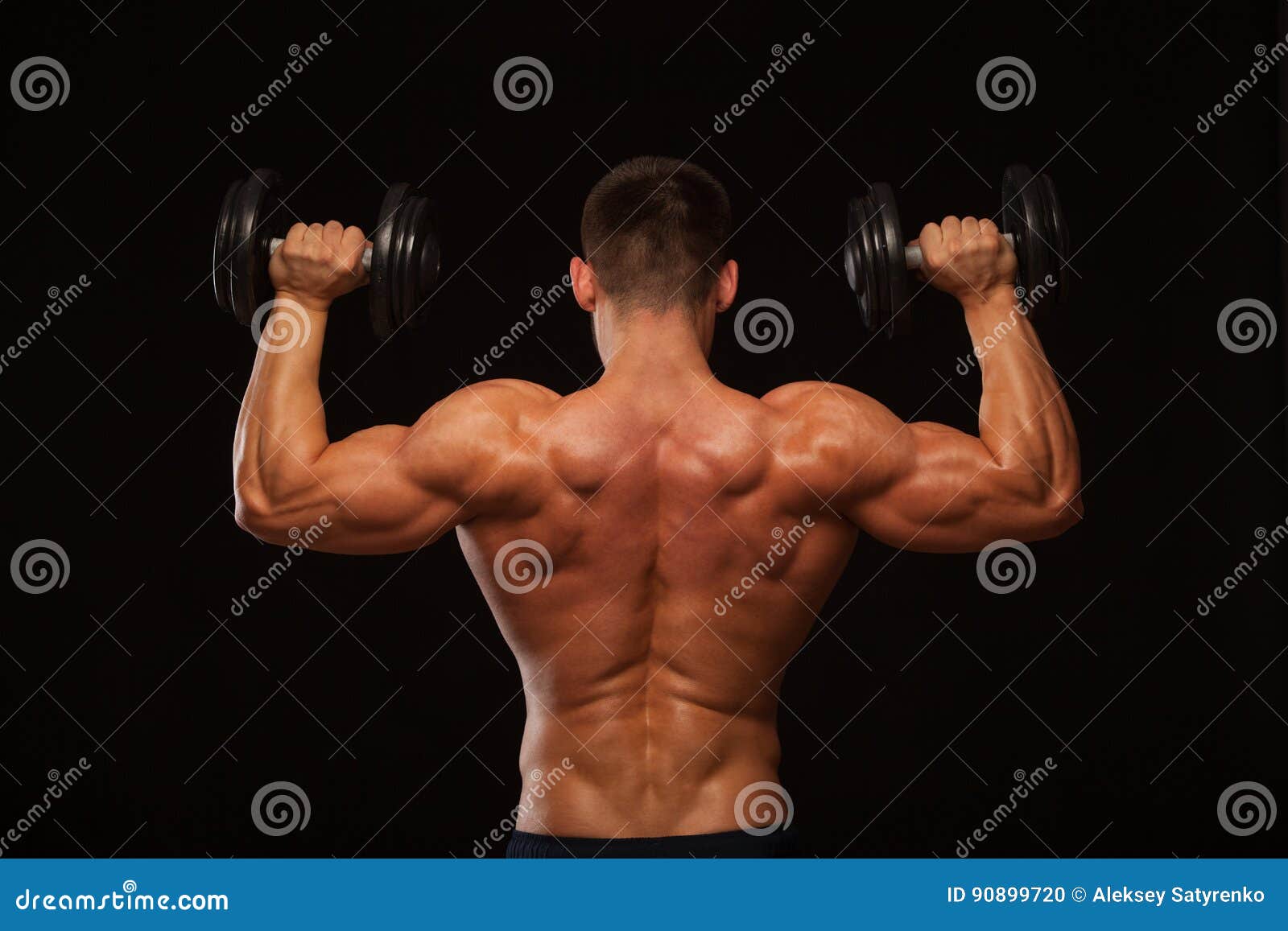 Muscular Male Model Bodybuilder Doing Exercises with Dumbbells, Turned ...