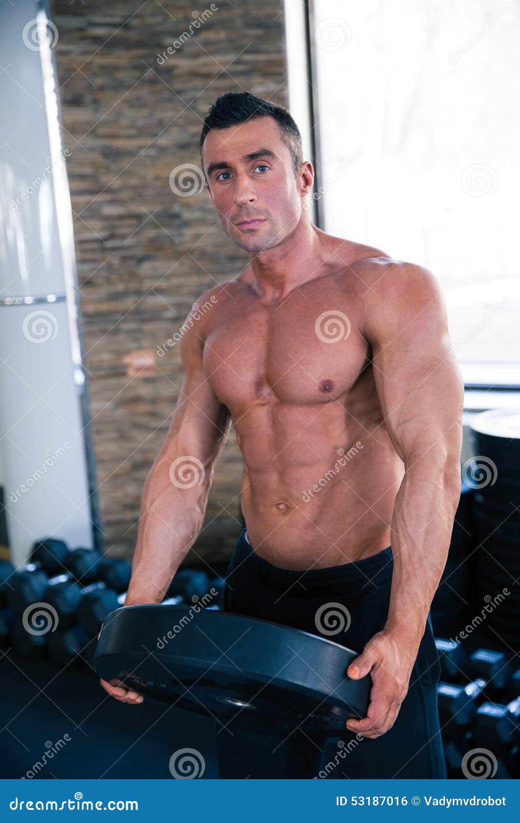 Muscular Man Holding Weight and Looking at Camera Stock Photo - Image ...
