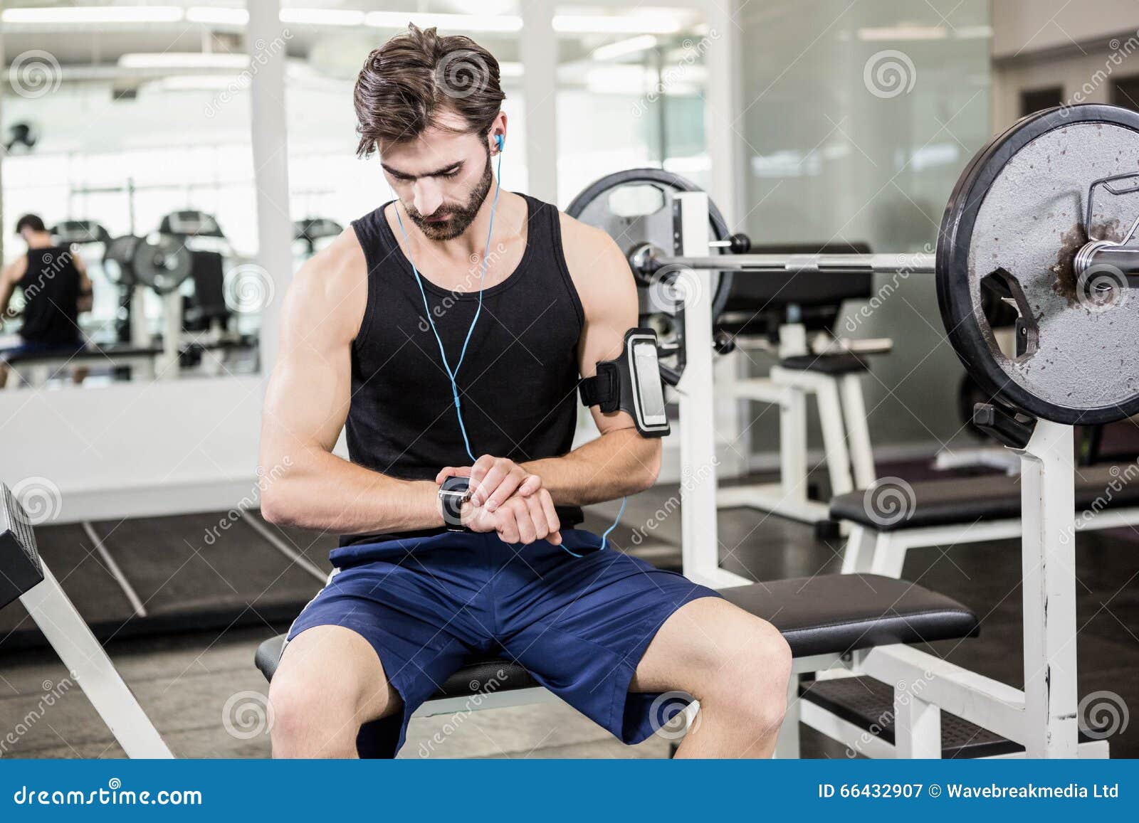 Muscular Man Sitting on Barbell Bench and Using Smartwatch Stock Image ...