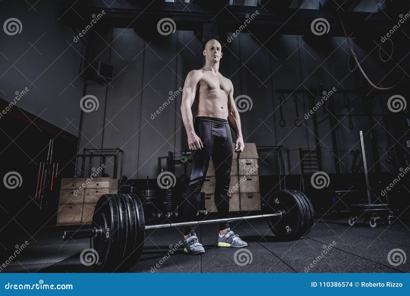 Muscular Man Standing at Barbells before Exercise. Stock Photo - Image ...