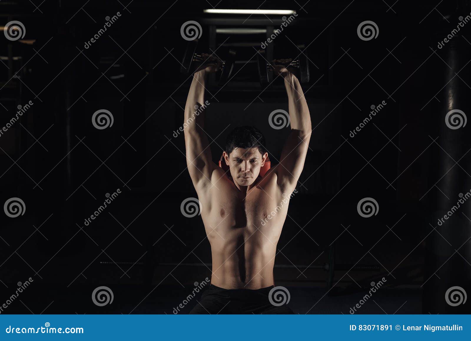 Muscular Man Training His Shoulders with Dumbbells. Stock Image - Image ...