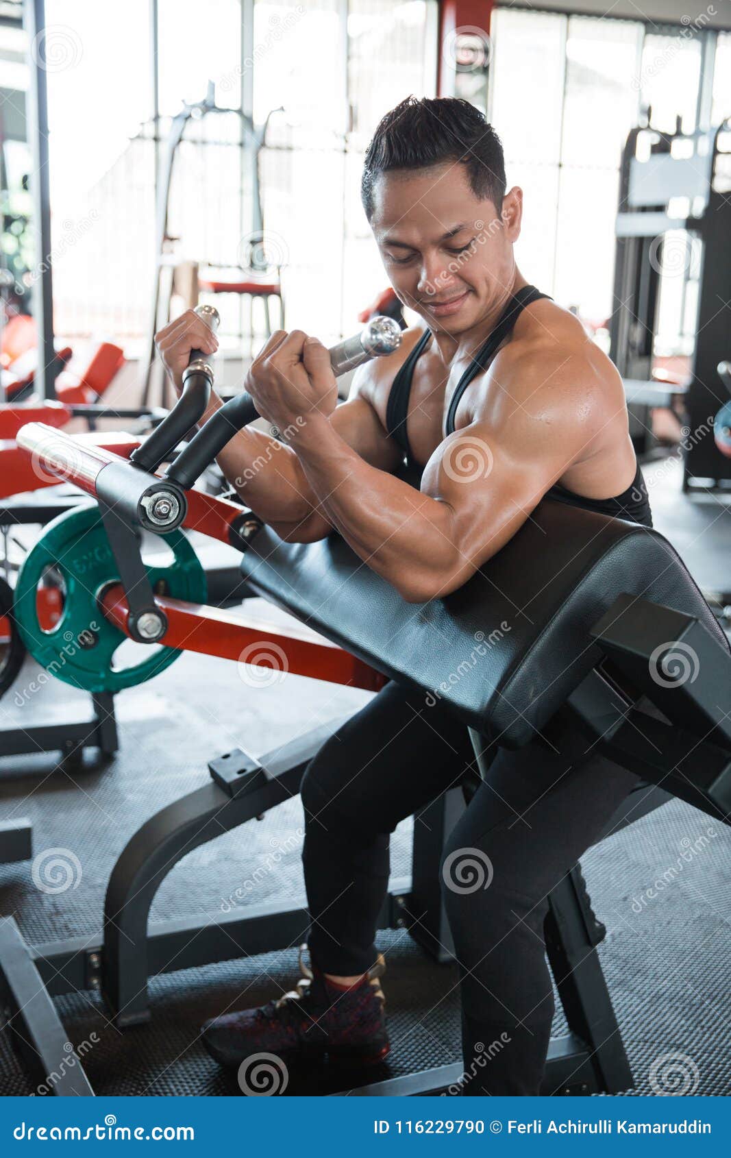 Muscular Man Workout on Exercise Machine Stock Photo - Image of ...