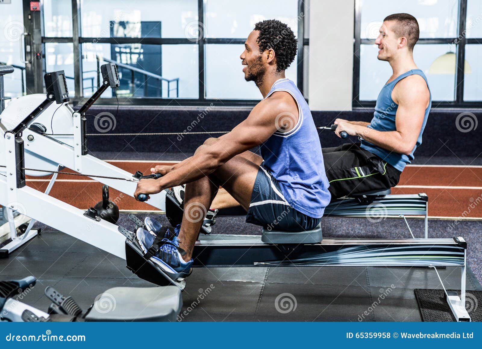 Muscular Men Using Rowing Machine Stock Photo - Image of body, exercise ...
